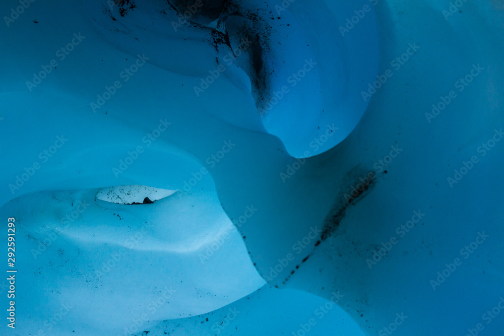 Ice arch with holes looking like eyes and a nose deep in an ice cave in ...