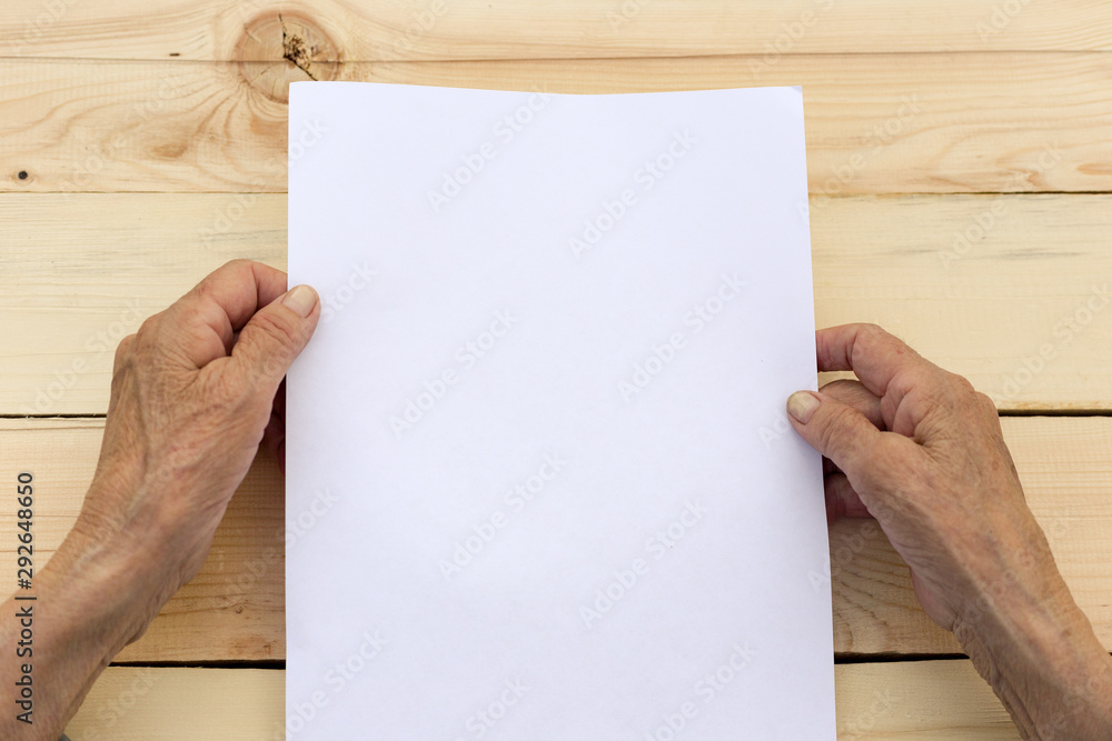 Old hands hold a blank sheet of paper. The concept of new beginnings ...