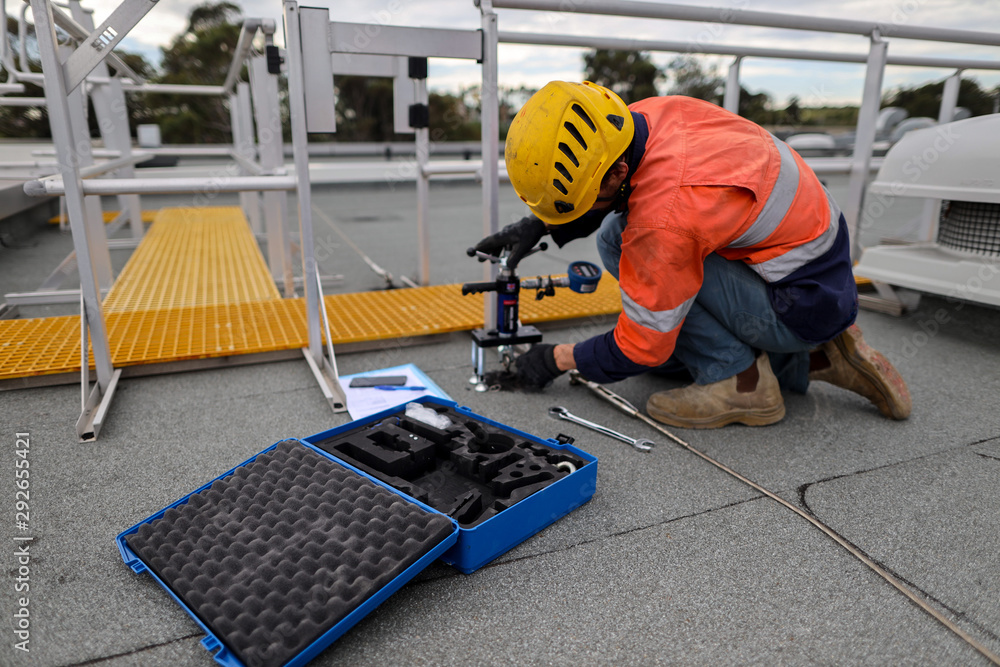 Rope access engineer conducting using pull machinery testing chemical ...