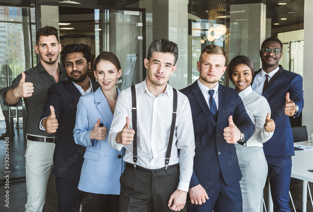 A team of young businessmen stand shoulder to shoulder, working and ...