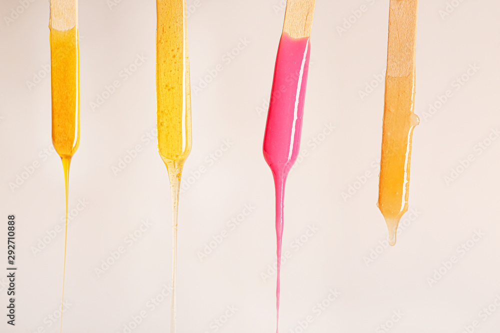 Sticks with dripping sugaring paste on light background Stock Photo ...