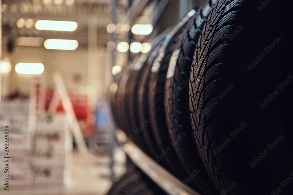 Brand new big variety of car's tyres on shelf with prices at store or ...