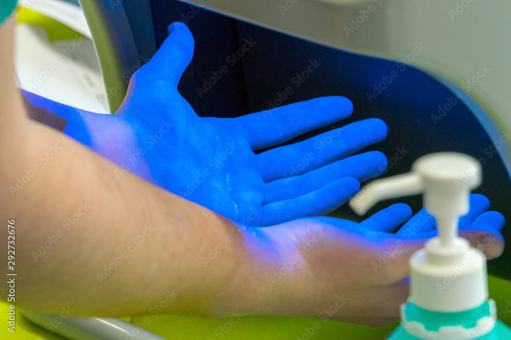Someone has disinfected his hands and controls the result under uv ...