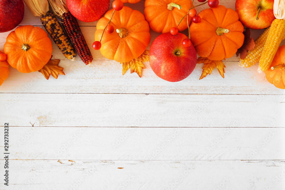 Autumn top border of leaves, pumpkins, apples and fall decor on a white ...