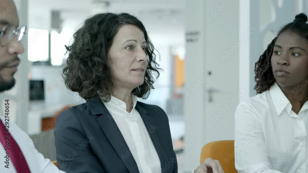 Middle aged businesswoman talking with colleagues. Multiethnic group of ...
