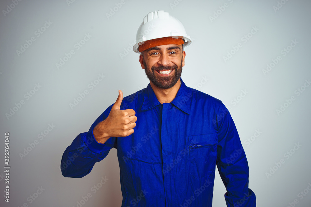 Handsome indian worker man wearing uniform and helmet over isolated ...