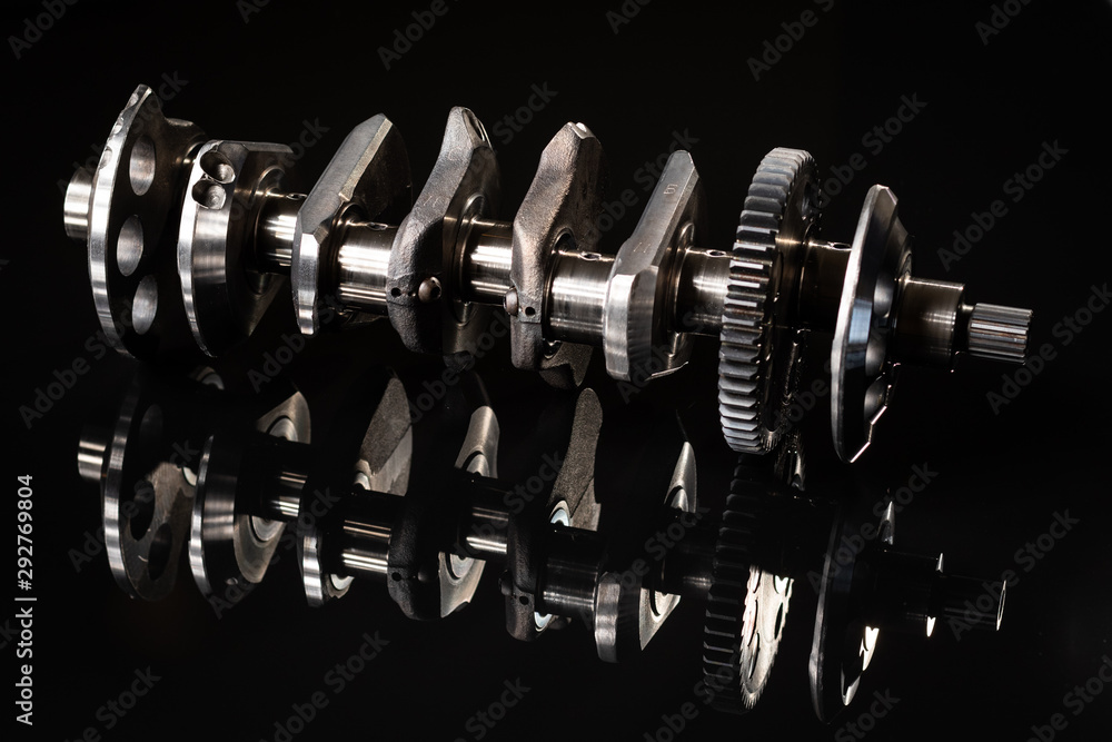 high performance racing motorcycle crankshaft on a reflective black ...