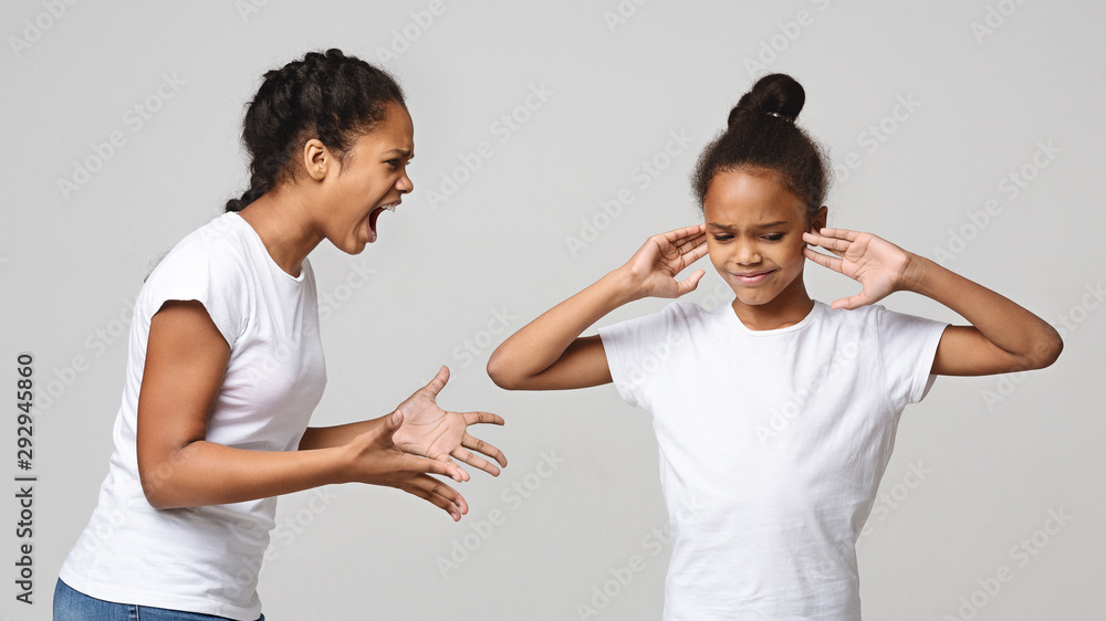 African sisters fighting over grey studio background Stock Photo ...