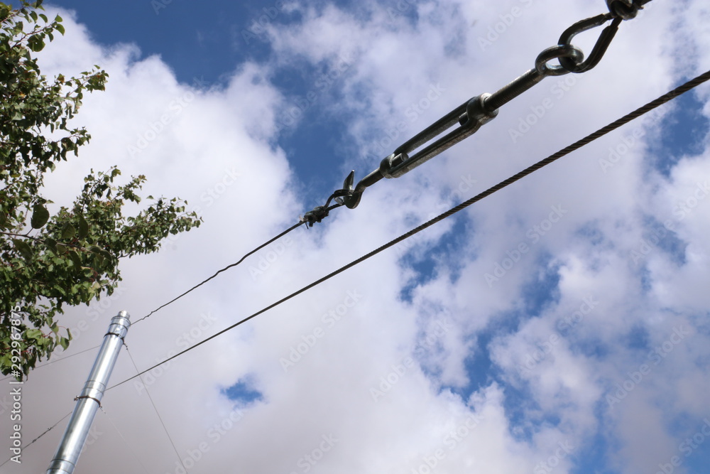 Tensioned cable on the hook. Clamps and tensioning cables. The ...