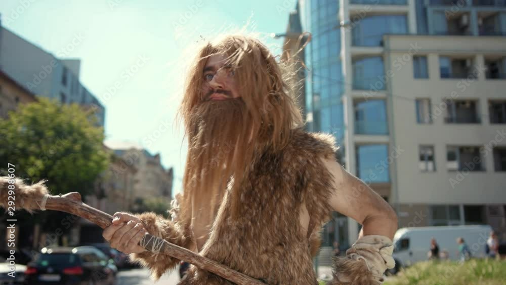 Neanderthal bushman of hunter-gatherers in animal fur holding ...