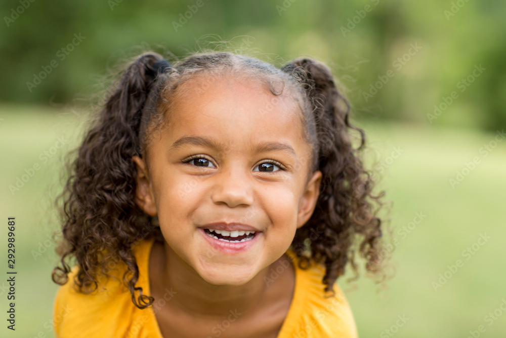 Cute mixed race little girl laughing and smiling. Stock Photo | Adobe Stock