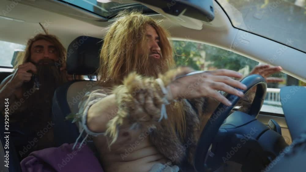 Prehistoric wild furious taxi driver wearing animal fur driving car ...