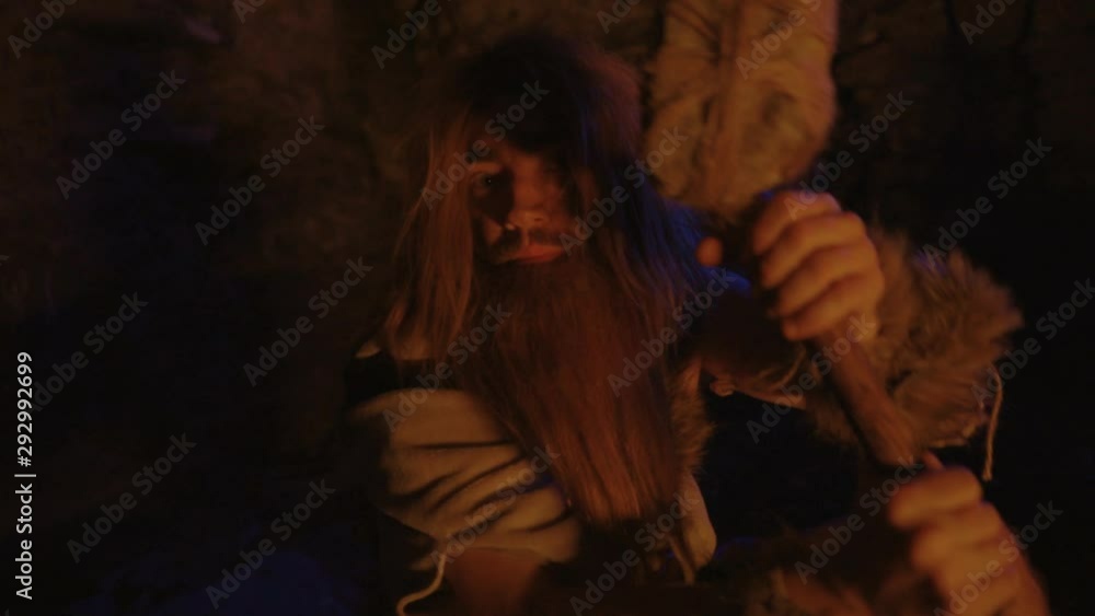 Neanderthal of stone-age period covered in hair holding survival spear ...