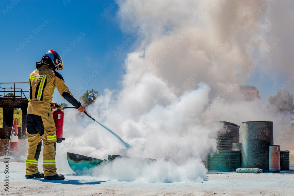 firefighter putting out a fire with a fire extinguisher Stock Photo ...