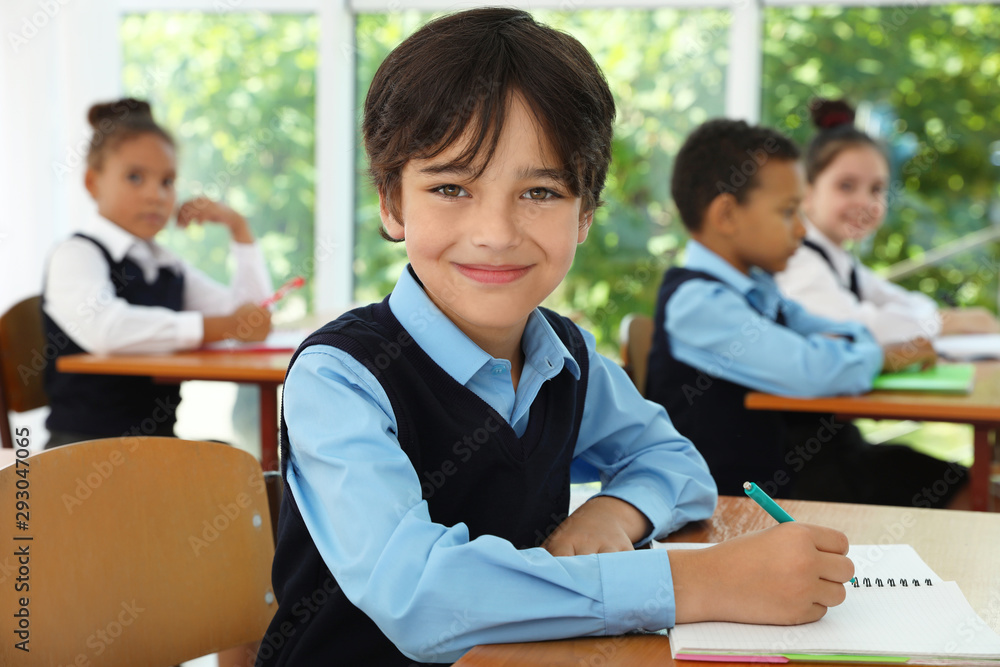 Boy wearing new school uniform in classroom Stock Photo | Adobe Stock