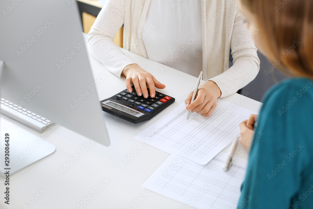 Accountant checking financial statement or counting by calculator ...