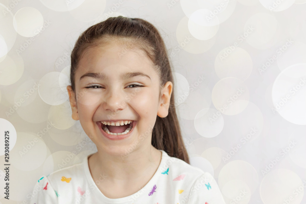 Portrait of happy adorable laughing child girl on light background ...