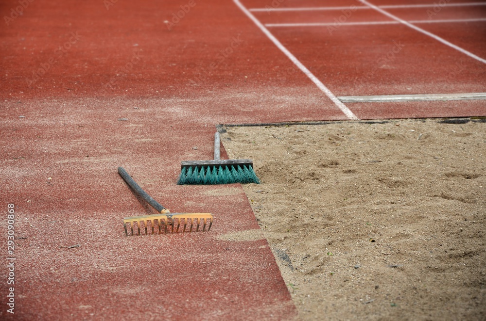 piste d’athlétisme, bac à sable, râteau et balai Stock-Foto | Adobe Stock