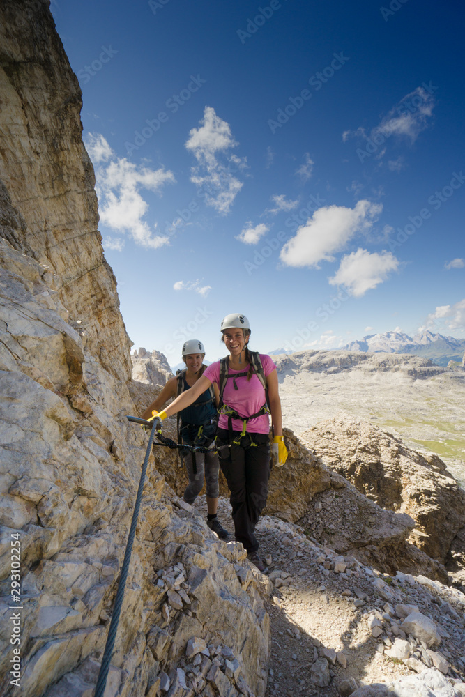 attractive female climbers on a steep Via Ferrata in the Italian ...