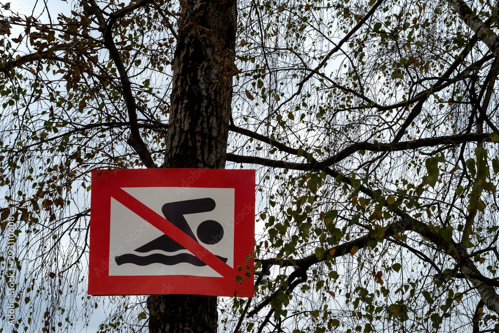 Warning sign bathing is prohibited. Information sign on the tree. Stock ...