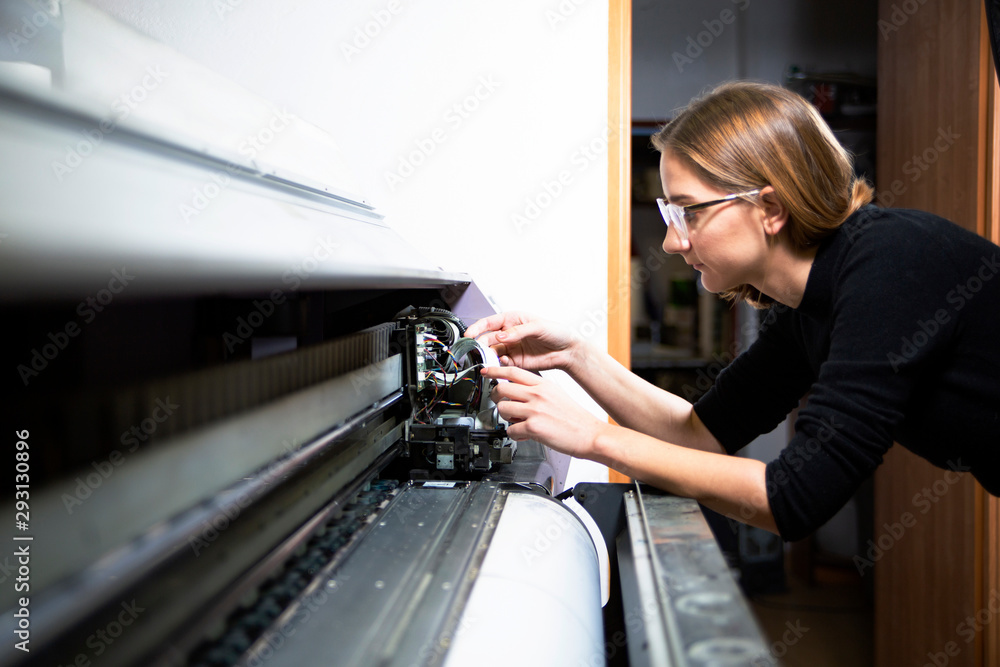 Printing house. The employee operates the printing machine Stock Photo ...