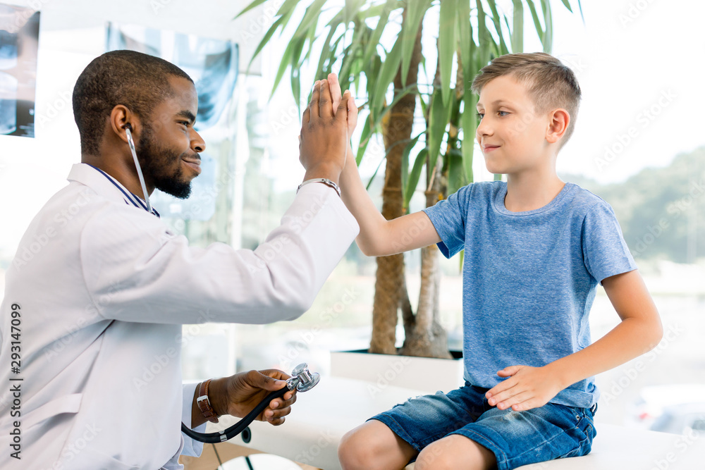 Happy smiling African American male doctor giving five to a little boy ...