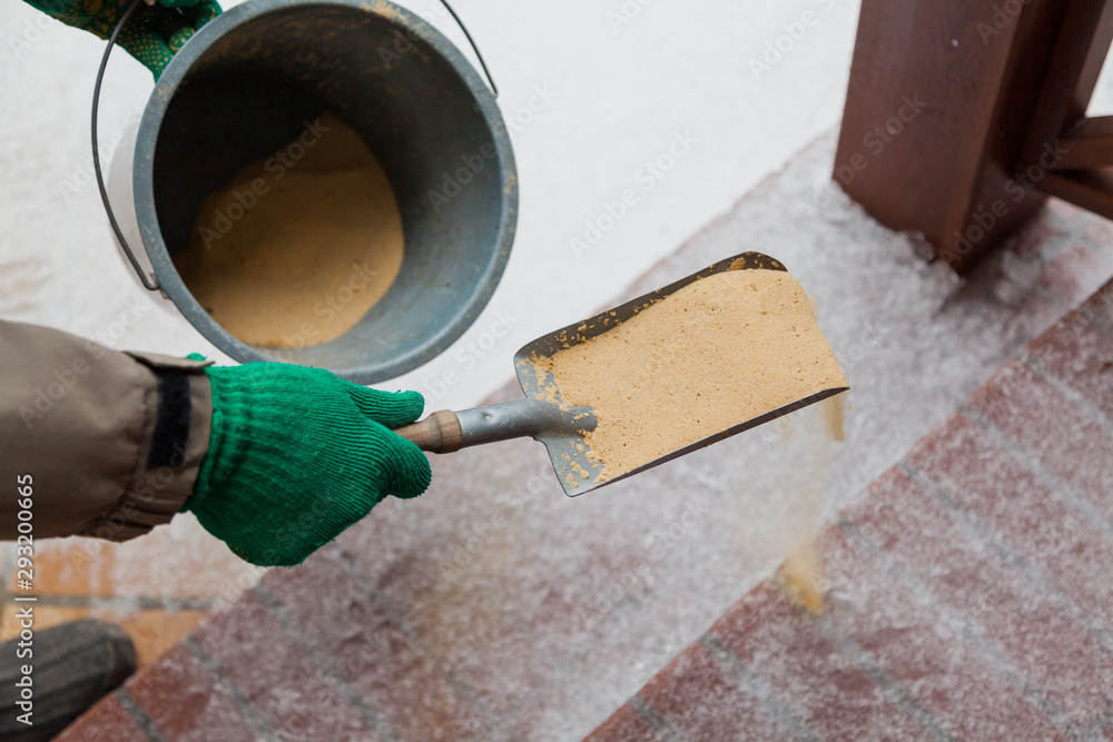 Hand sprinkles brick steps with dry sand Stock Photo | Adobe Stock