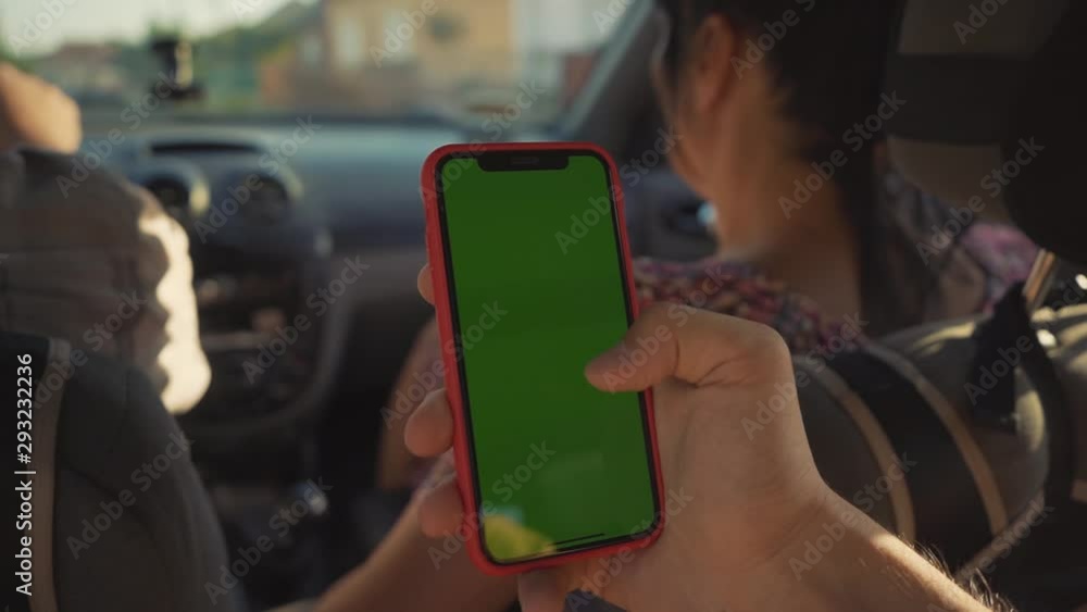 Close up man hands use smartphone with vertical green screen in car background people in car ...