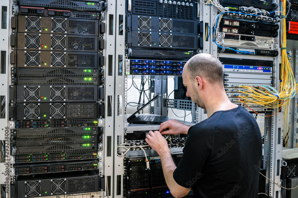 The system administrator works in the server room. A man connects the ...