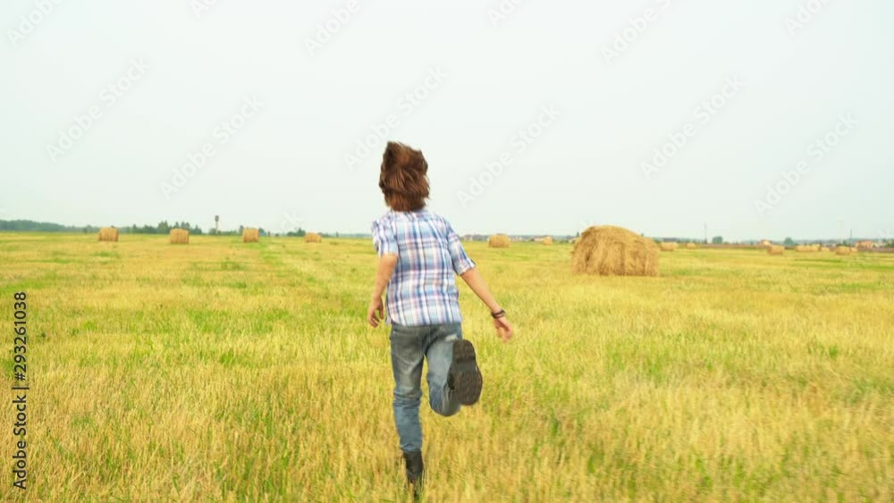 Boy teenager running away on autumn field in countryside. Back view ...