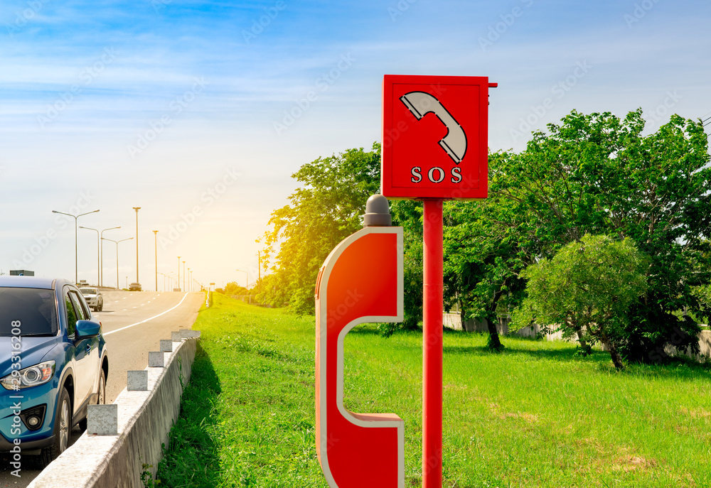 Blue SUV car parked at roadside near emergency SOS telephone. Highway ...