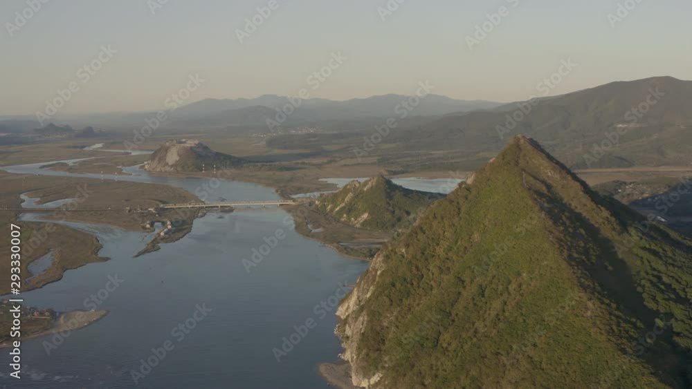Landscape view of a river estuary with two pyramid-shaped mountains and ...