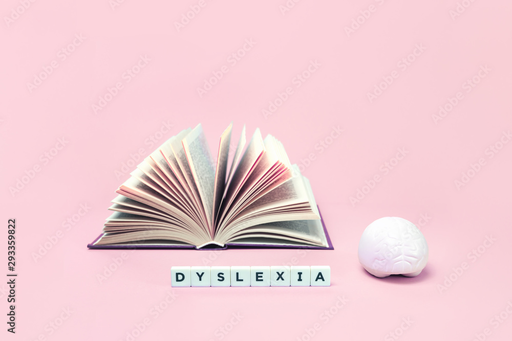 Dyslexia word with a brain stress relief and open book on pink ...