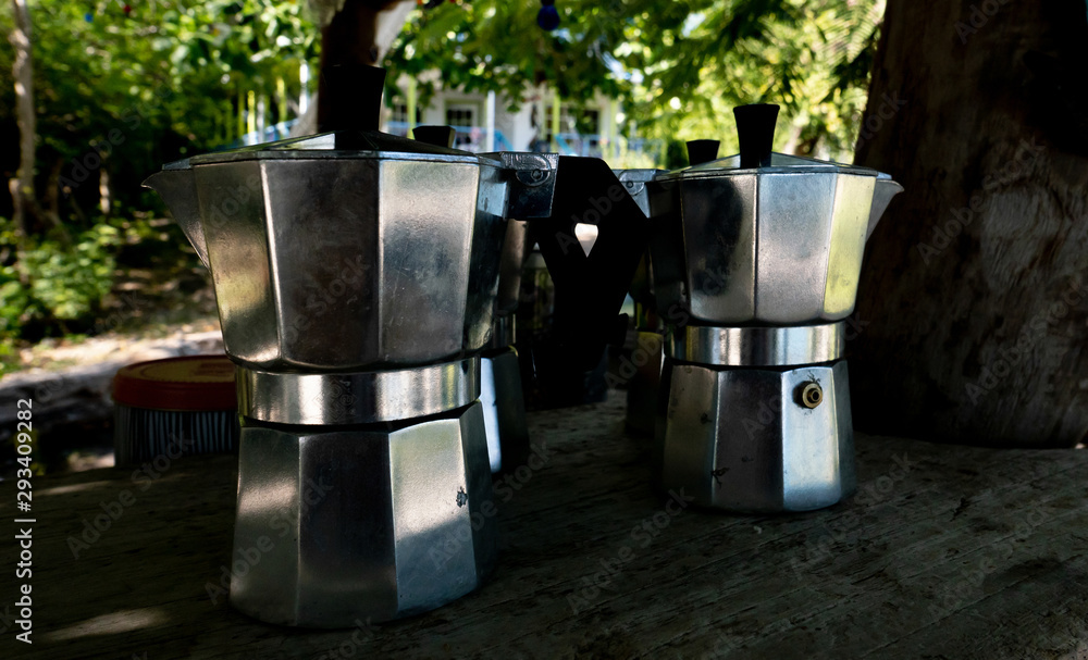 three manual coffee makers for preparing espresso with a garden ...