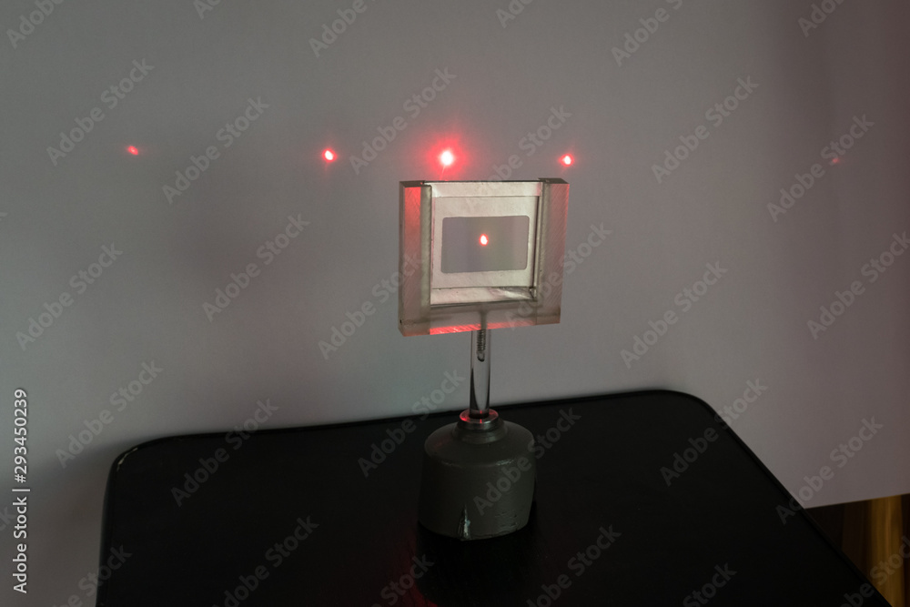 Red laser light passes through a grating, causing diffraction. Physics ...