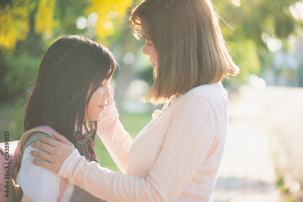 Asian mother saying goodbye to her daughter as she leave for School ...