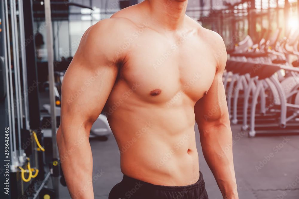 Muscular bodybuilder Man showing muscular body and sixpack abs at a gym ...