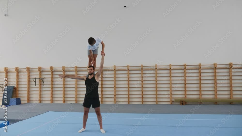 Vidéo Stock A young boy athlete is slowly making a handstand with one ...