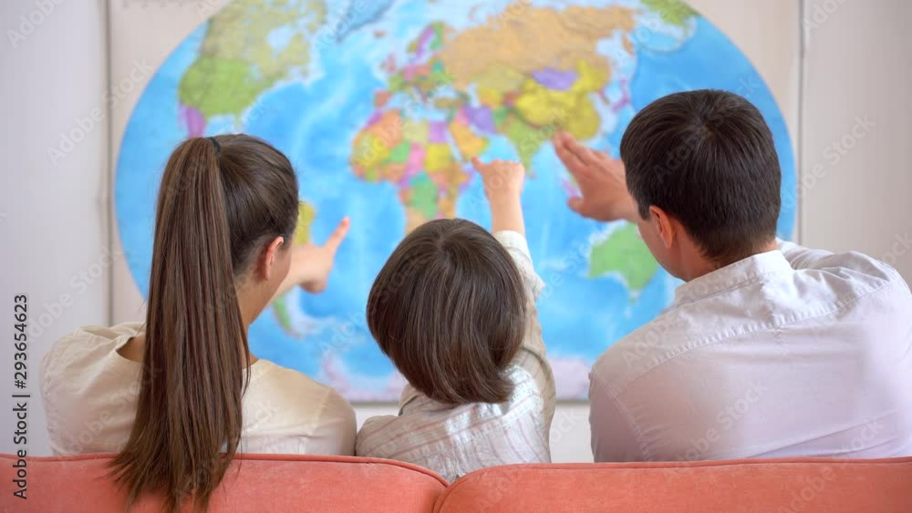 Happy family tourists traveler looking at world map planning travel ...