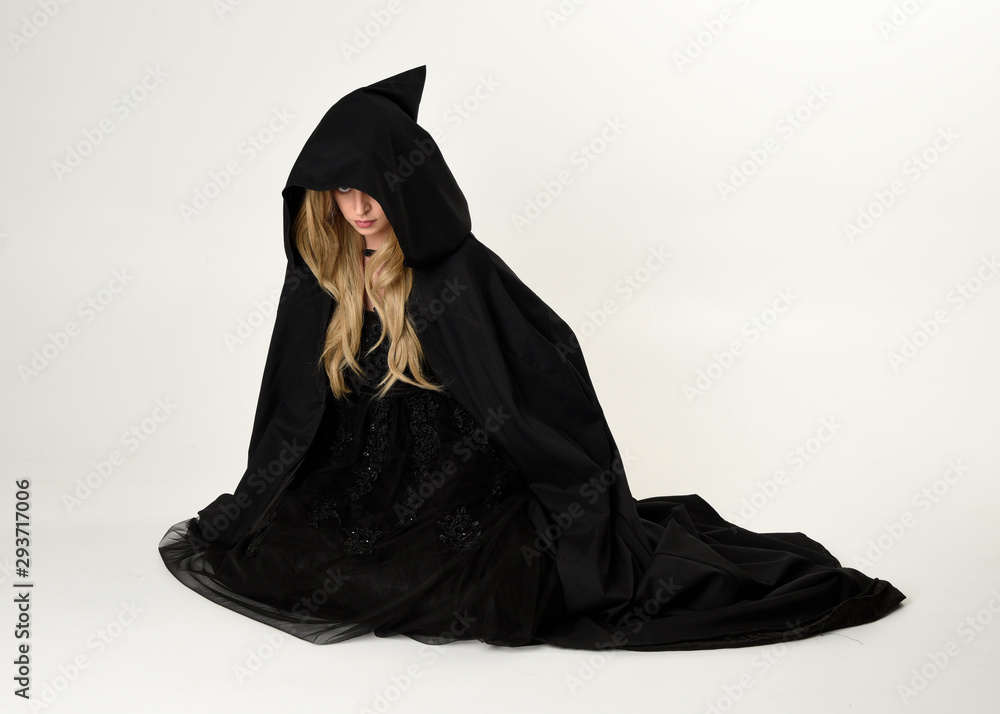 full length portrait of blonde girl wearing long black flowing cloak ...
