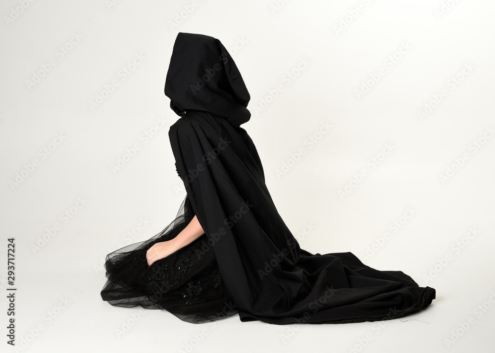full length portrait of blonde girl wearing long black flowing cloak ...