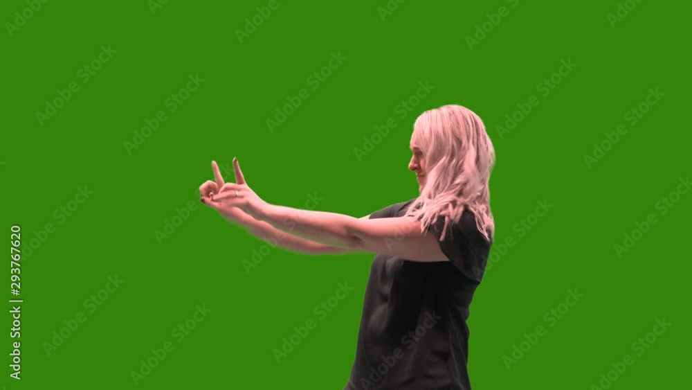 Female model on green screen stands waving her hands to the left side ...