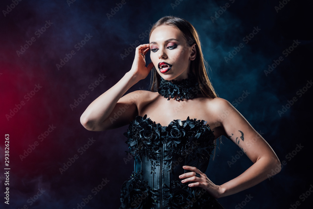 Poster scary vampire girl with fangs in black gothic dress on black ...