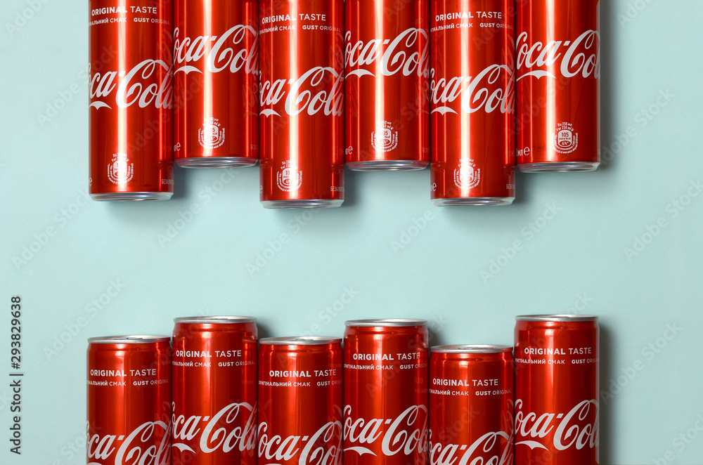 Flat lay shot carbonated red drink tin cans Coca Cola laying on pastel ...