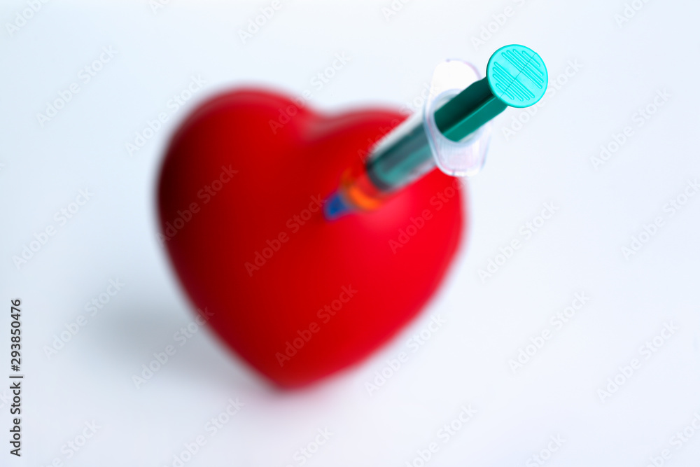 Red heart with stuck syringe on gray background. Cardiac surgery for ...