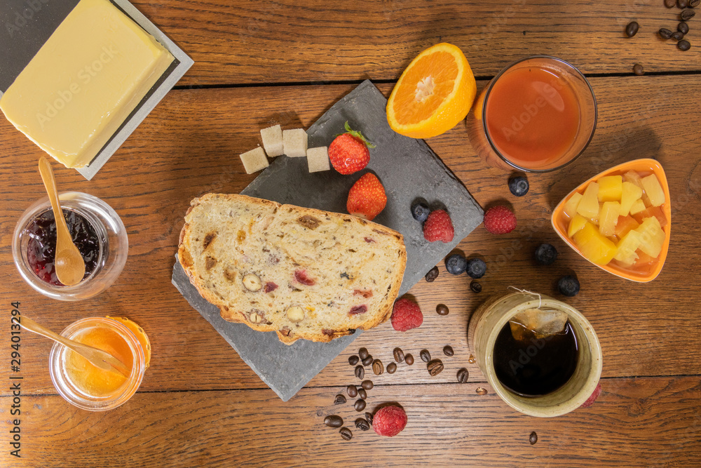 Bon petit déjeuner varié avec pain aux fruits secs et céréales jus d'orange frais miel et ...