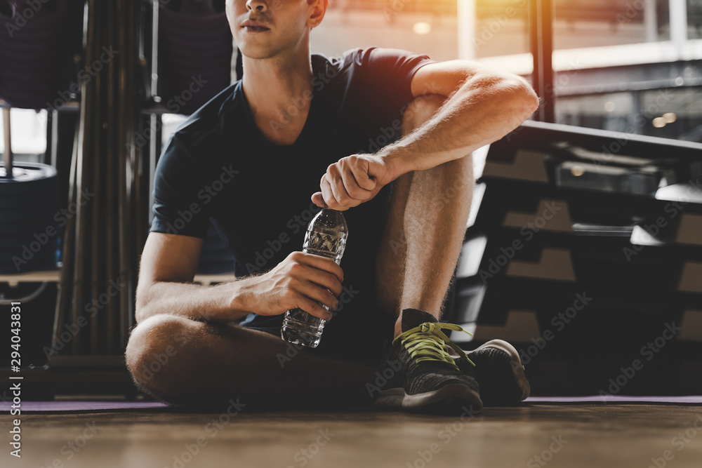 muscular caucasian young handsome man taking a break relax and drinking ...