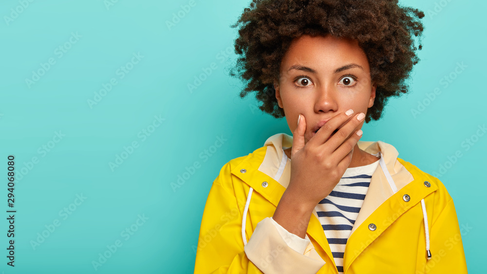 Emotional scared woman keeps palm on mouth, screams from shock, wears ...