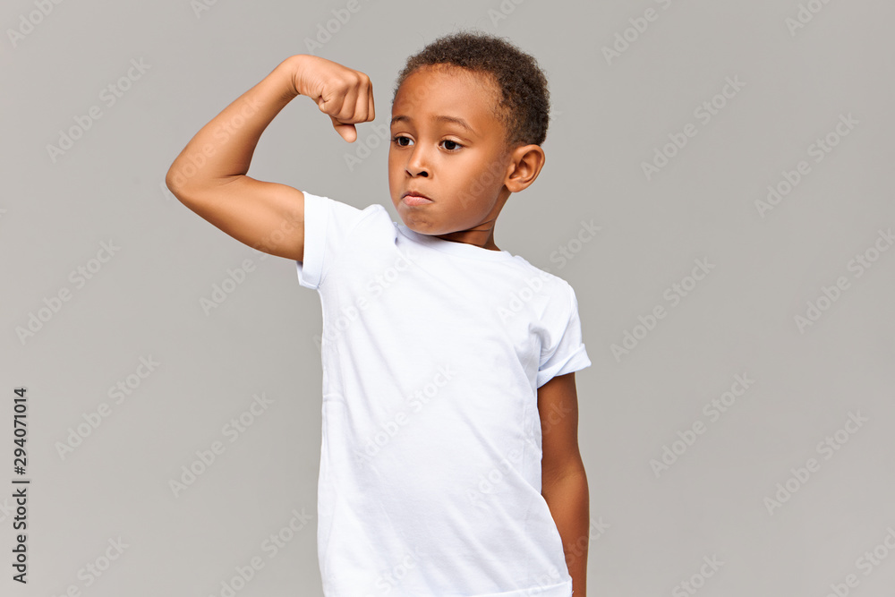 Foto Stock Cute dark skinned athletic male child with short Afro hairdo ...