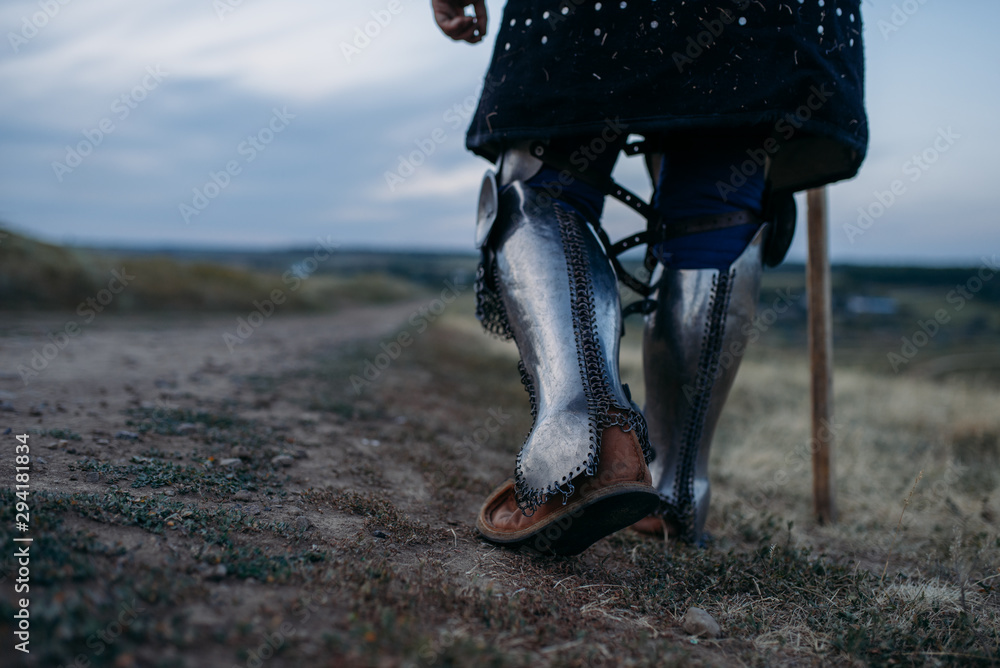Medieval knight legs in metal armor, back view Stock Photo | Adobe Stock
